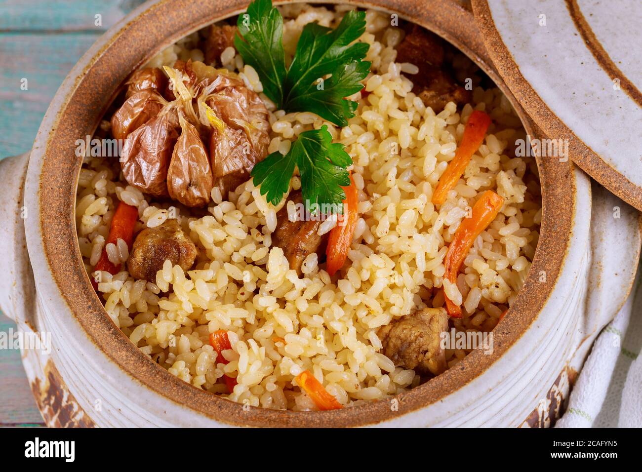 Rice with beef and vegetables in a clay pot with lid. Close up. Asian ...