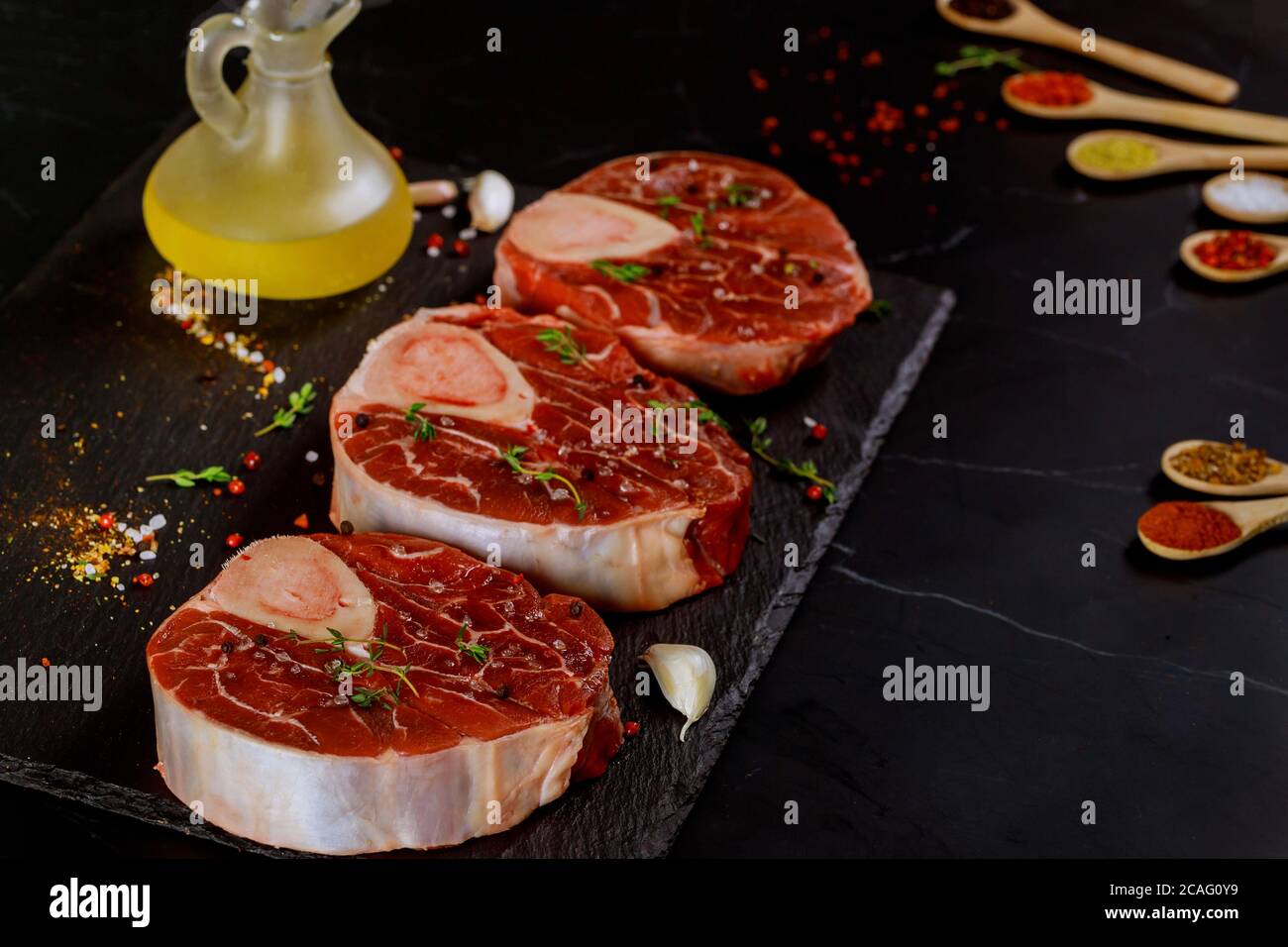 Three pieces of raw fresh beef shank bone in with spices and olive oil ...