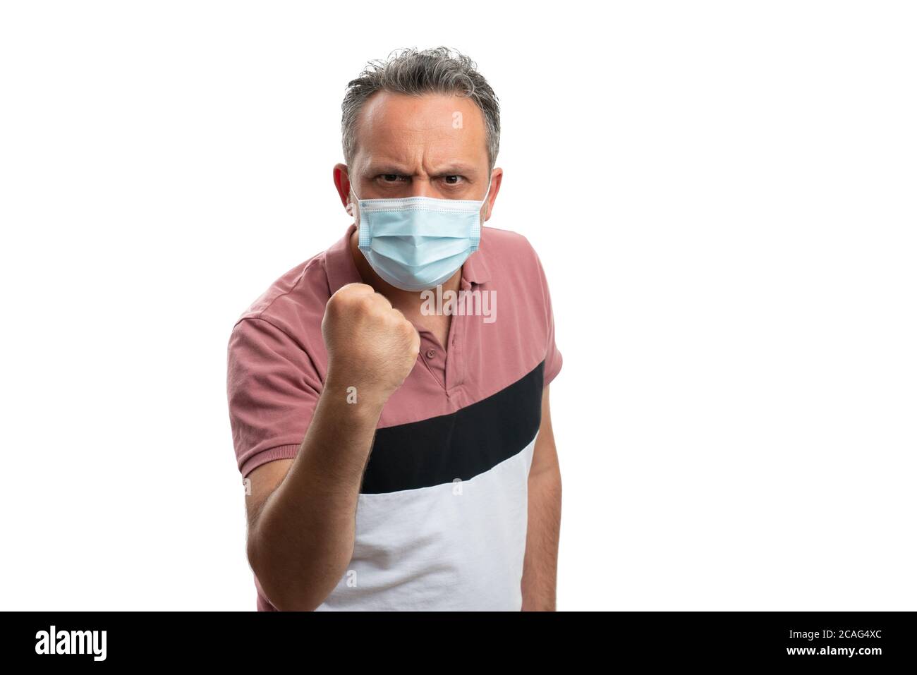 Adult man wearing mask to cover nose and mouth showing fist with angry ...