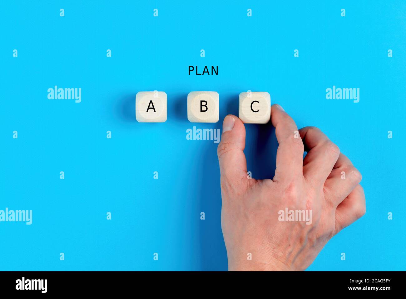 Male hand choosing a business strategy plan c out of three options ...