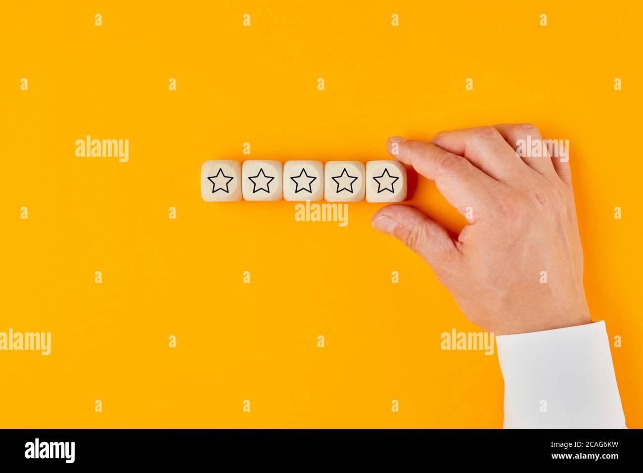 Hand of a businessman placing five star rating icon on wooden cubes in ...