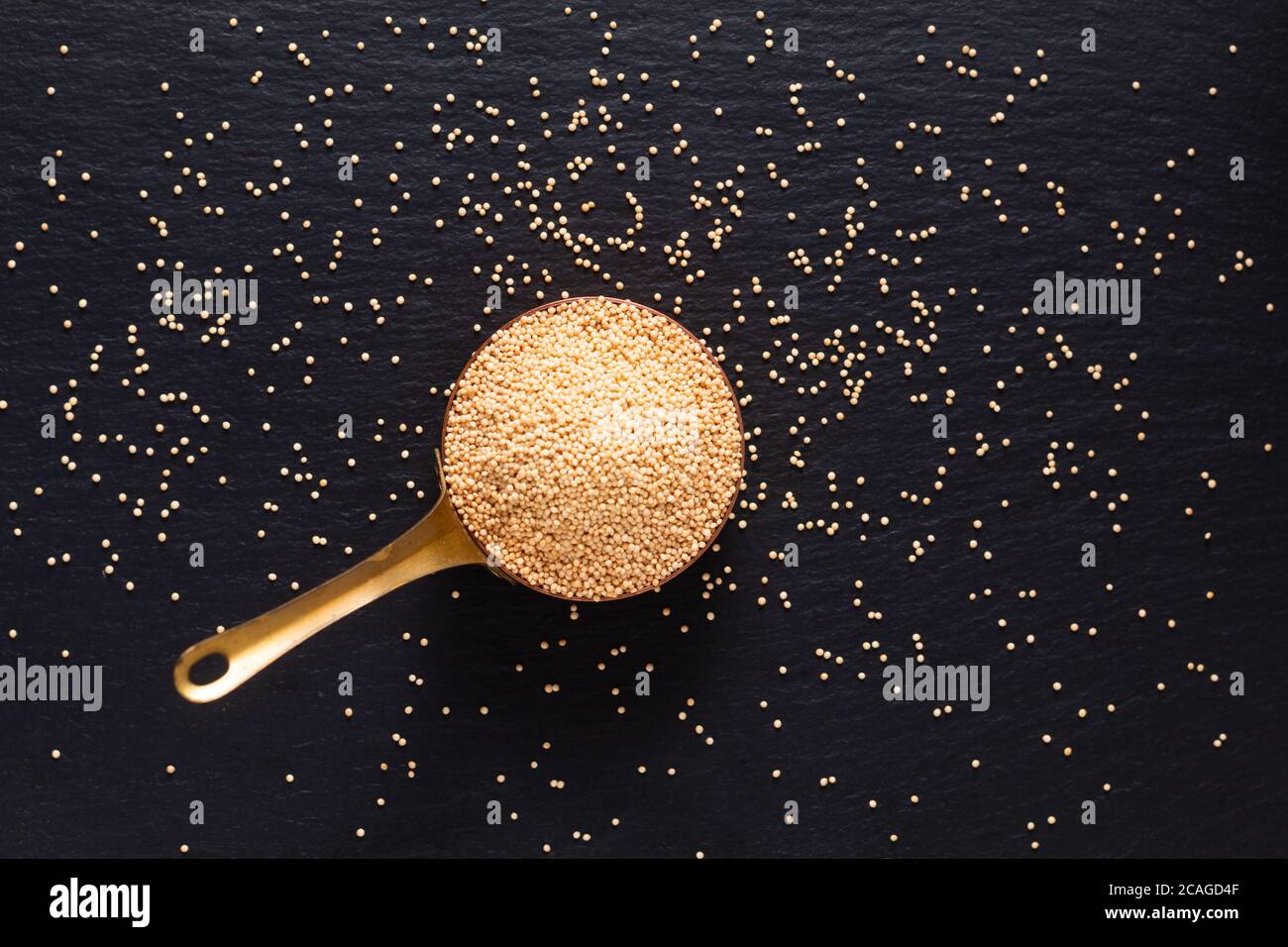 Food spices concept top view of organic amaranth in copper cup on black ...