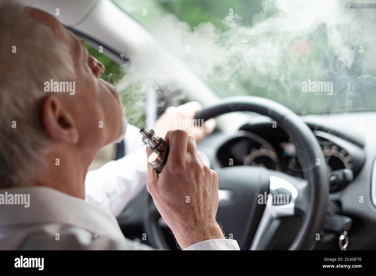 Man smoking an e-cigarette while driving Stock Photo - Alamy