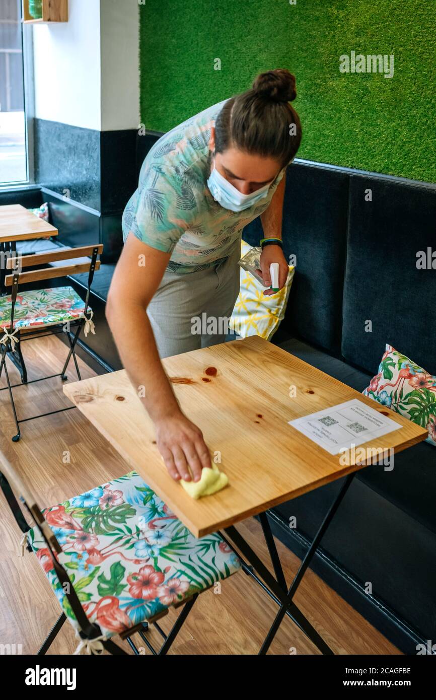 Waiter disinfecting tables due to coronavirus Stock Photo - Alamy
