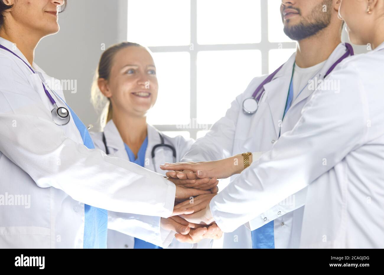 Team of medical workers holding hands together indoors, above view. Unity concept Stock Photo ...