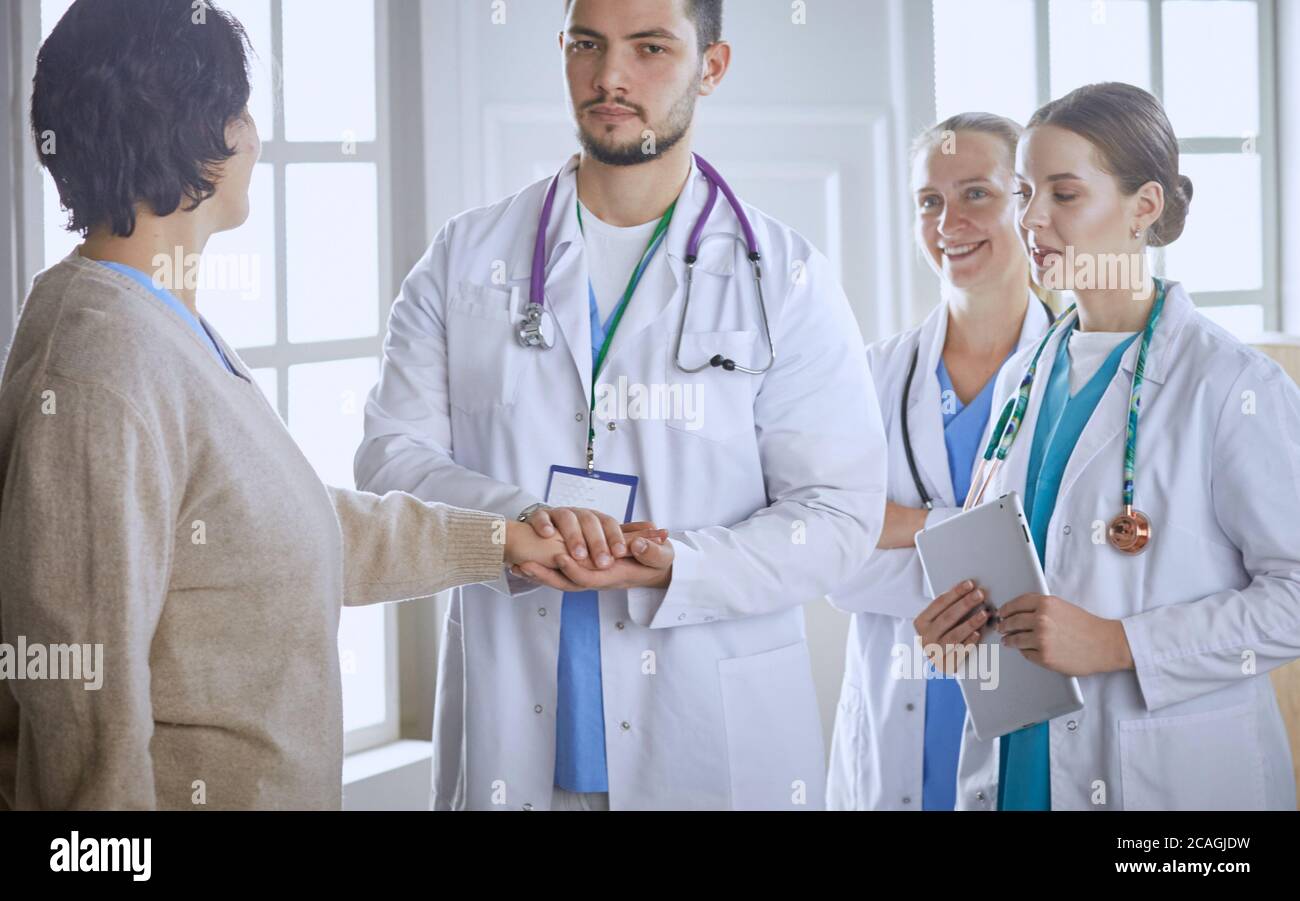 Patient with a group of doctors at the background Stock Photo - Alamy