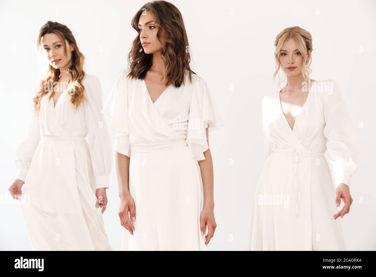 Photo of beautiful charming three women in dresses posing at camera ...
