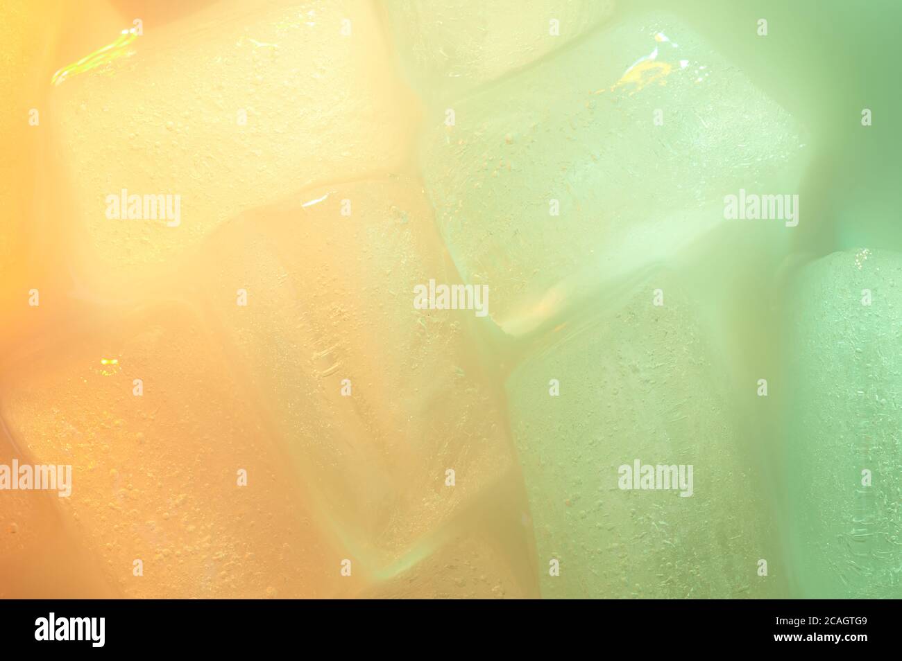 Pattern of green and yellow ice cubes close up view. Clear melt ice ...