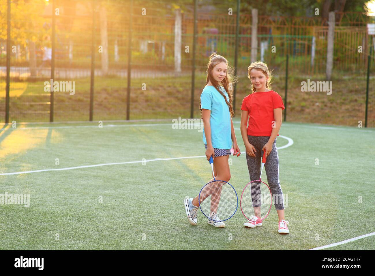 Two girls with badminton rackets on the football field Stock Photo - Alamy