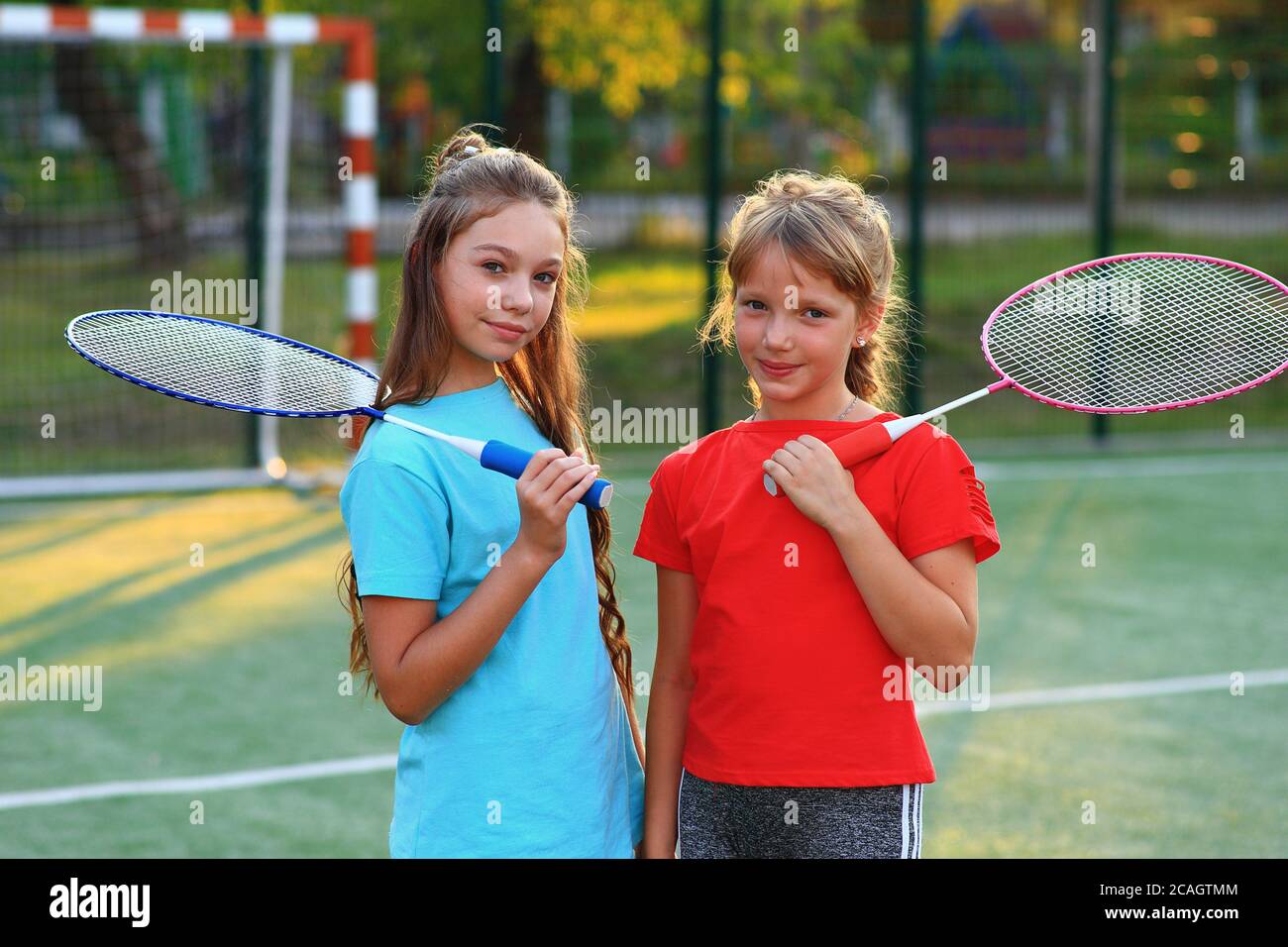 Two girls with badminton rackets on the football field Stock Photo - Alamy