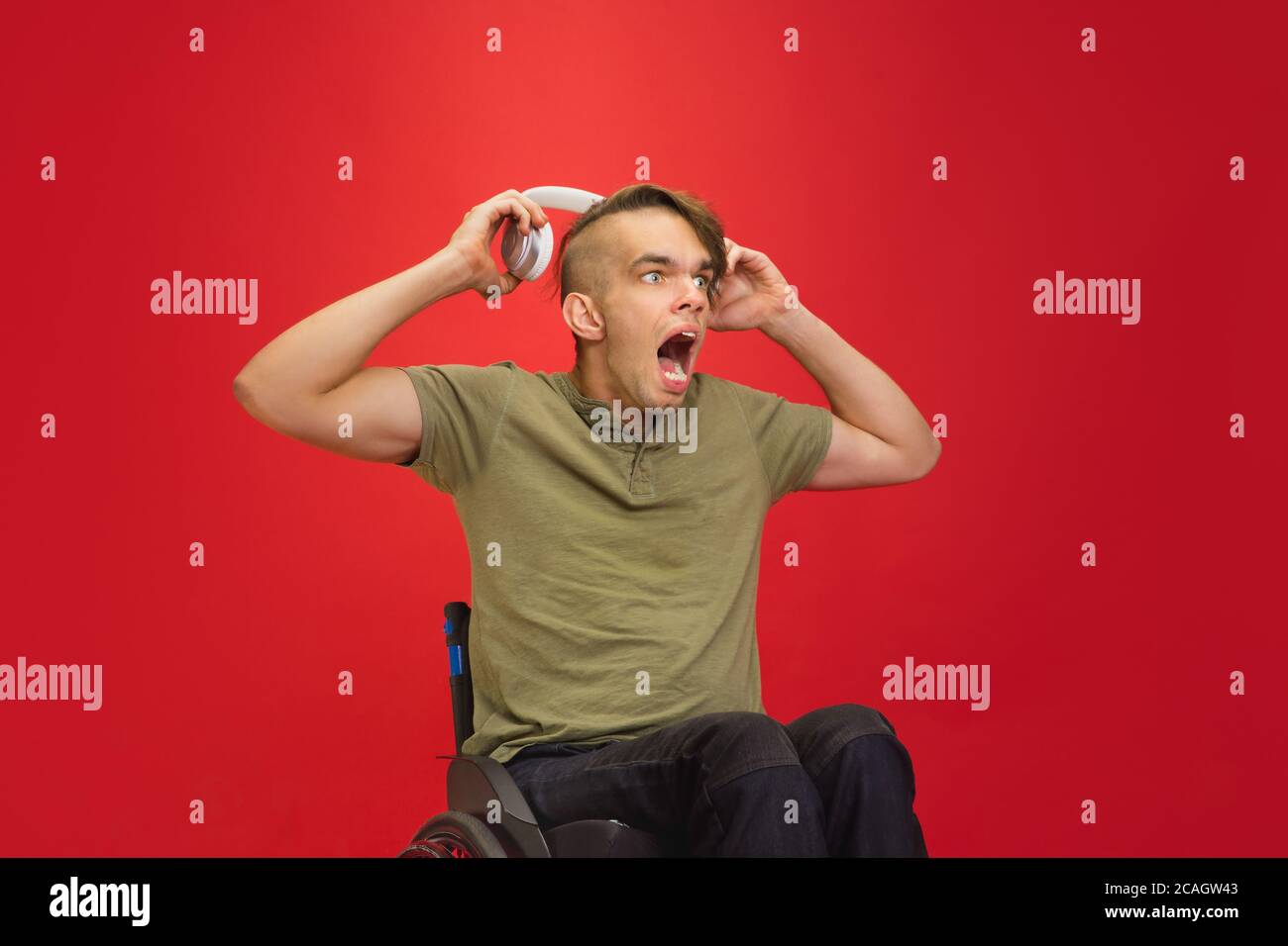 Listening to music. Caucasian young disabled man's portrait isolated on ...