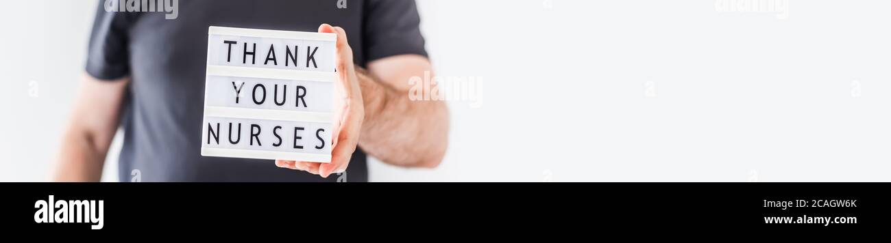 Nurse day concept. Man hands holding lightbox with text Thank your ...
