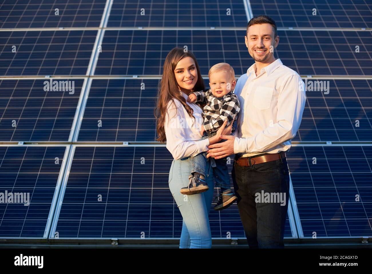 Portrait of a beautiful young family, smiling, standing together near ...