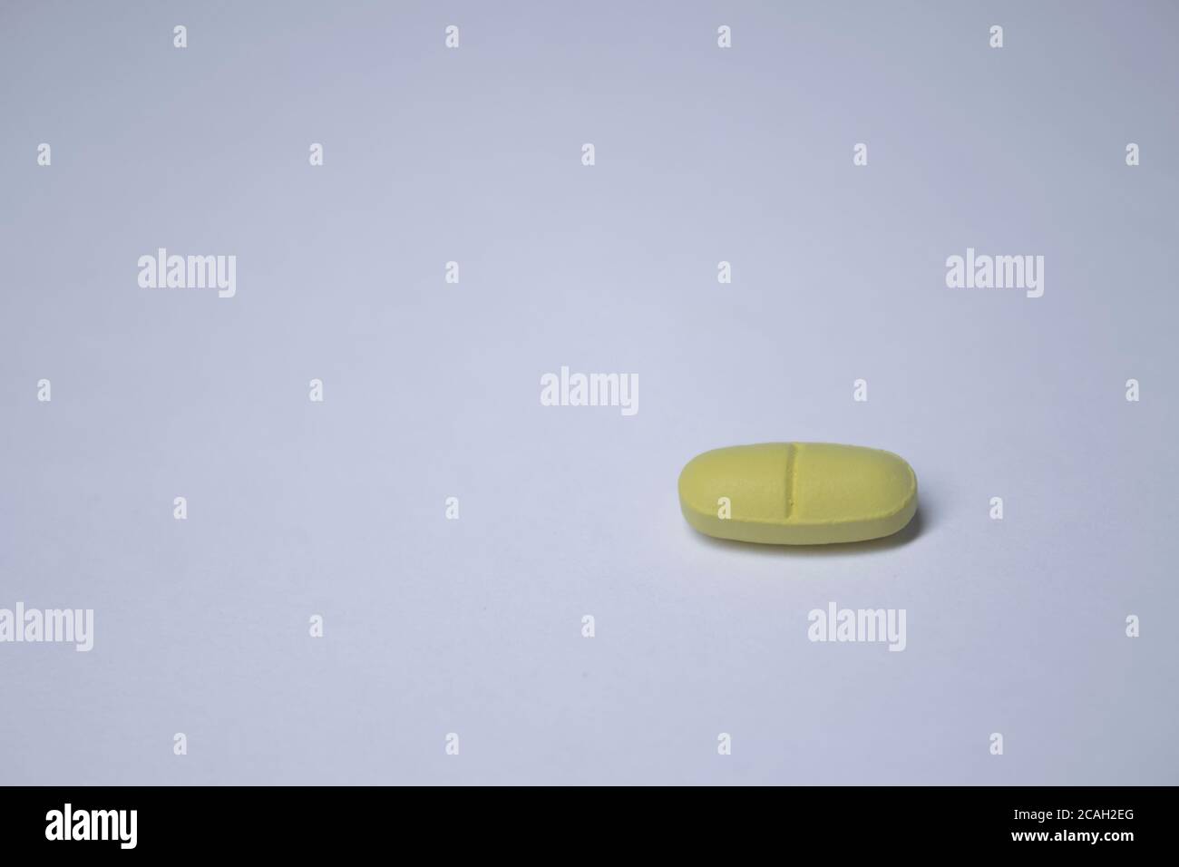 yellow tablet - pill on a white background. medicine and disease ...