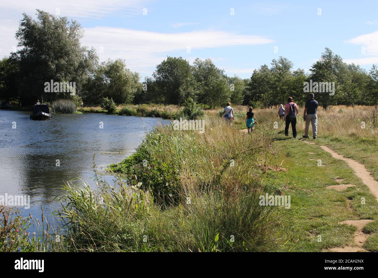 people walking along a river bank in summer Stock Photo - Alamy