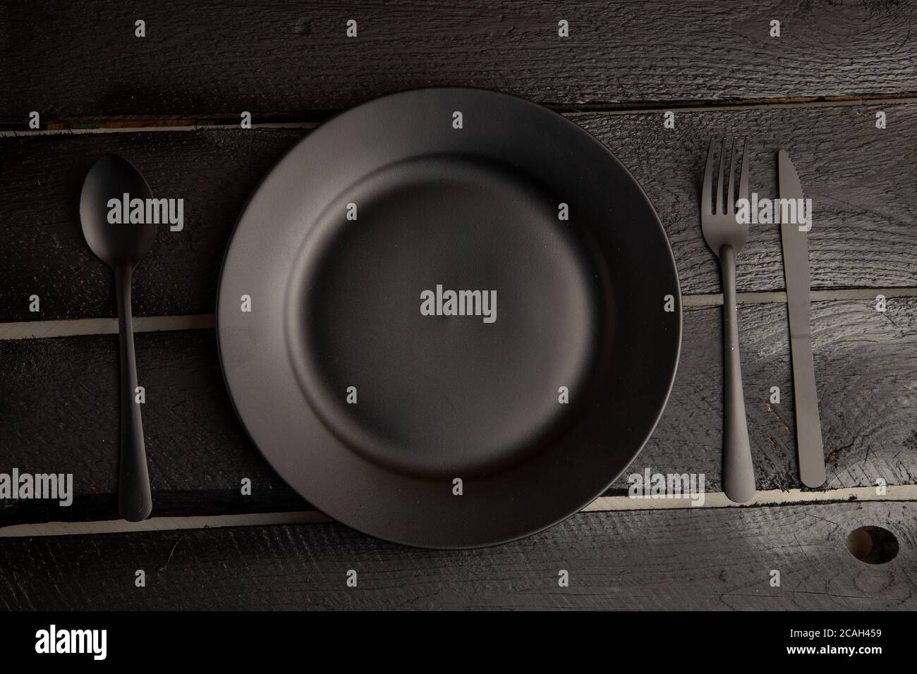 Top view of a black plate and cutlery on a kitchen table Stock Photo ...
