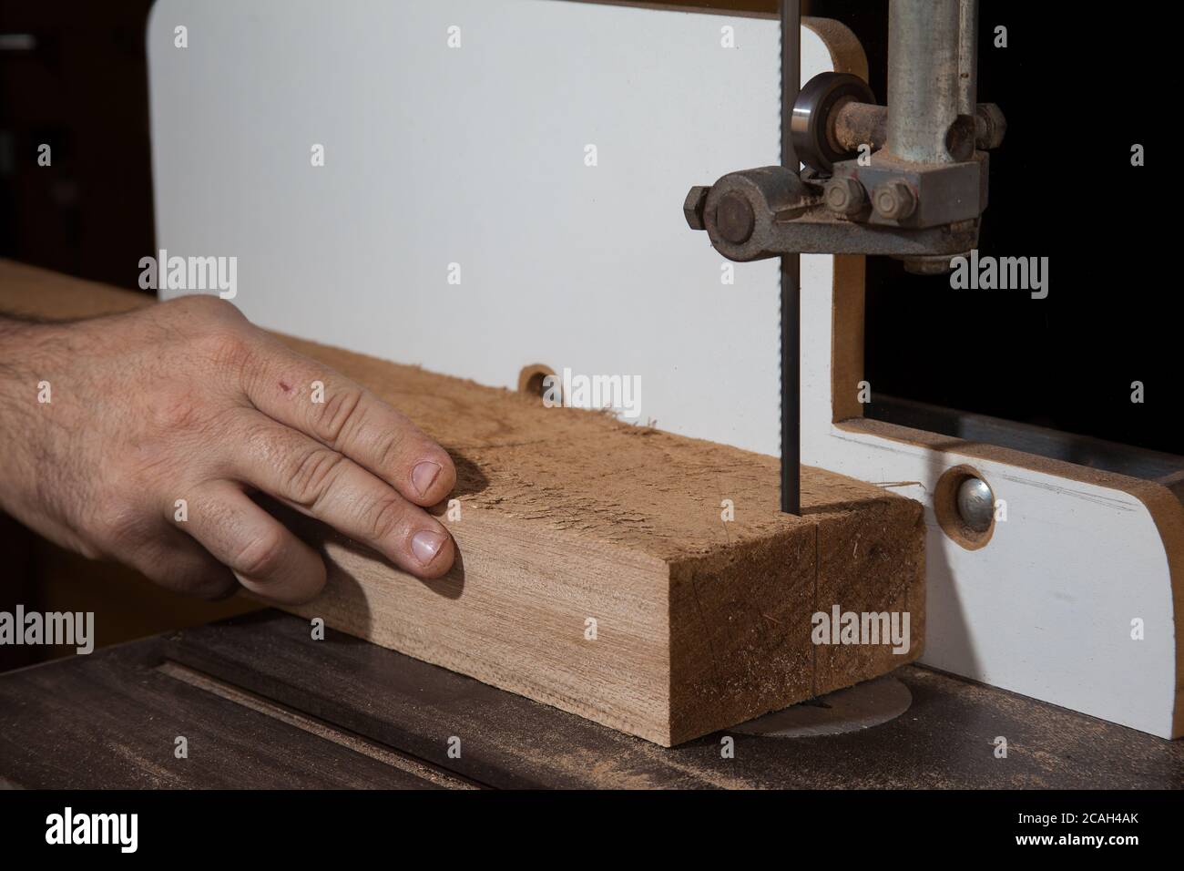 A craftsman cutting a plank of wood with bandsaw Stock Photo - Alamy