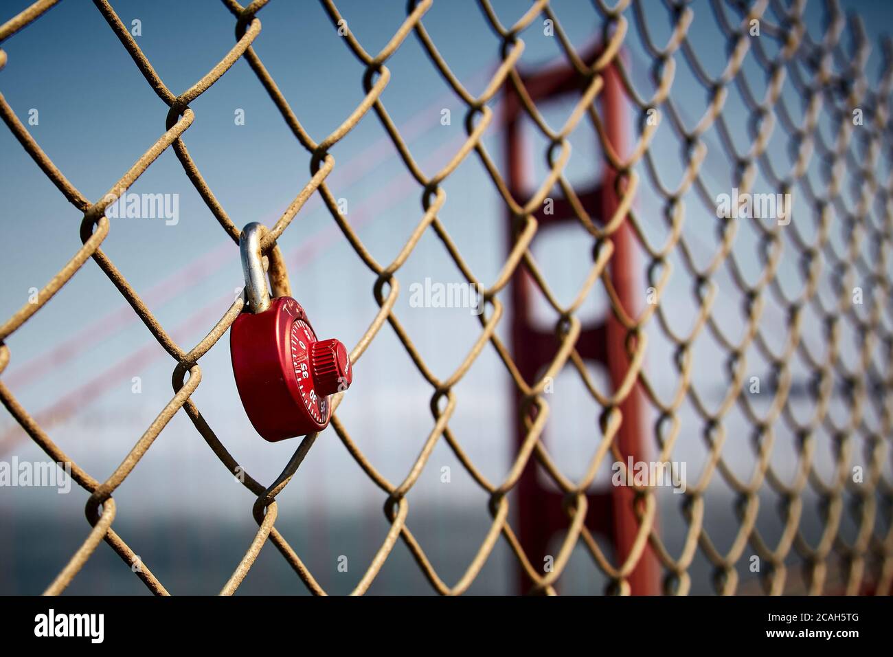 Soft focus of a red padlock hanging from a wire mesh fence Stock Photo ...