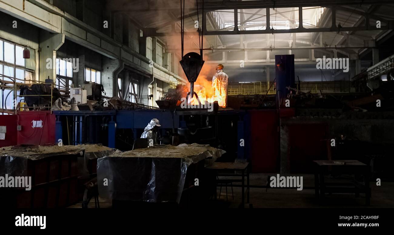 Smelting metal in a metallurgical plant. Liquid iron from metal ladle ...