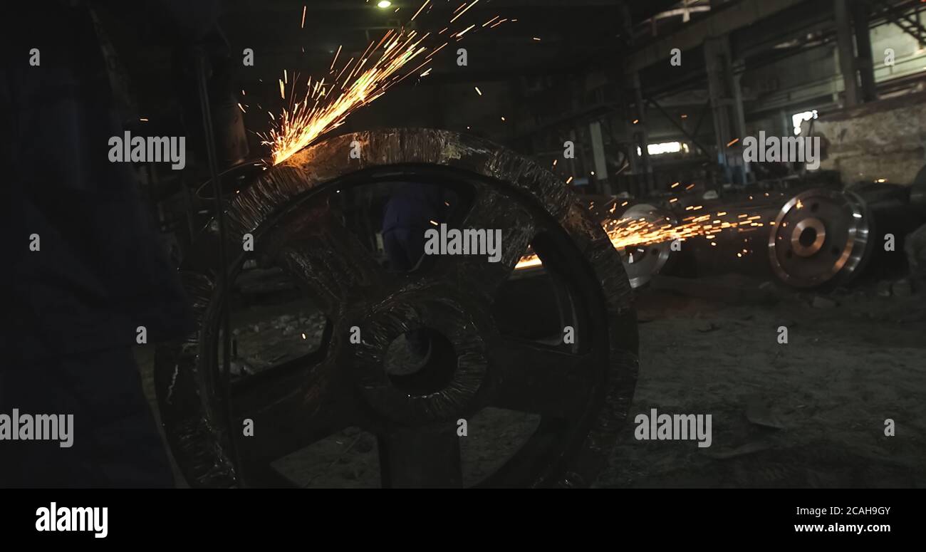 Working in a mask and headphones cleans joints angle grinder on metal ...