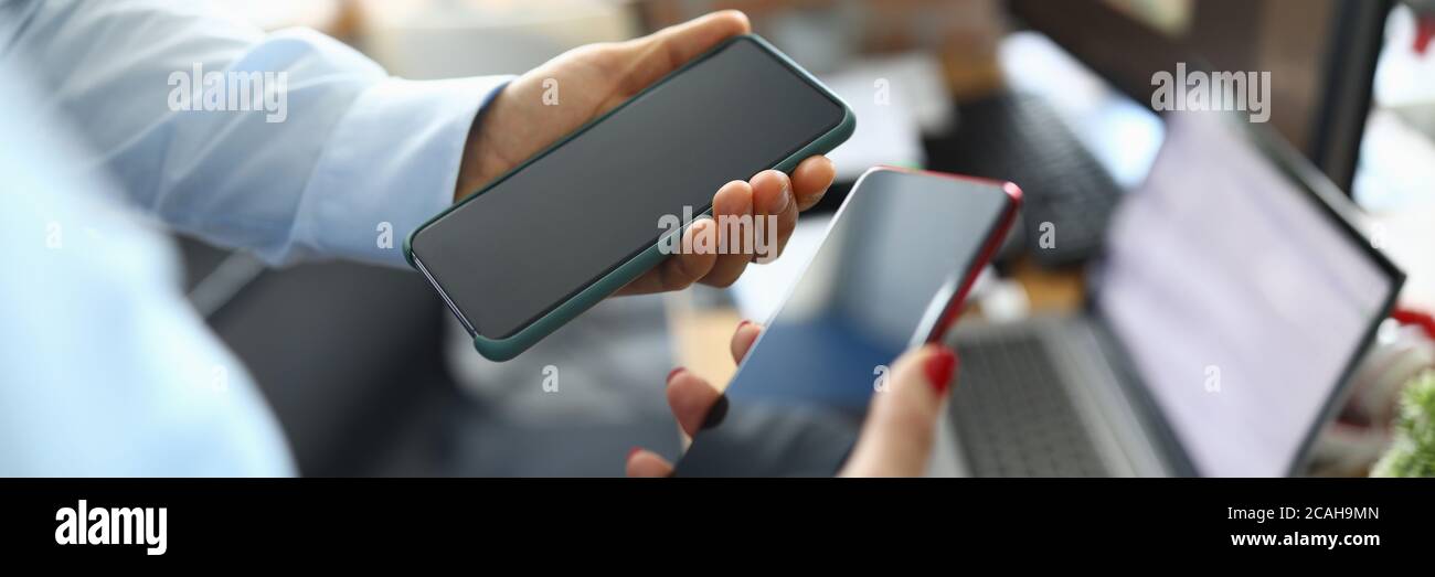 Two modern touch phones are held in hands of office Stock Photo - Alamy