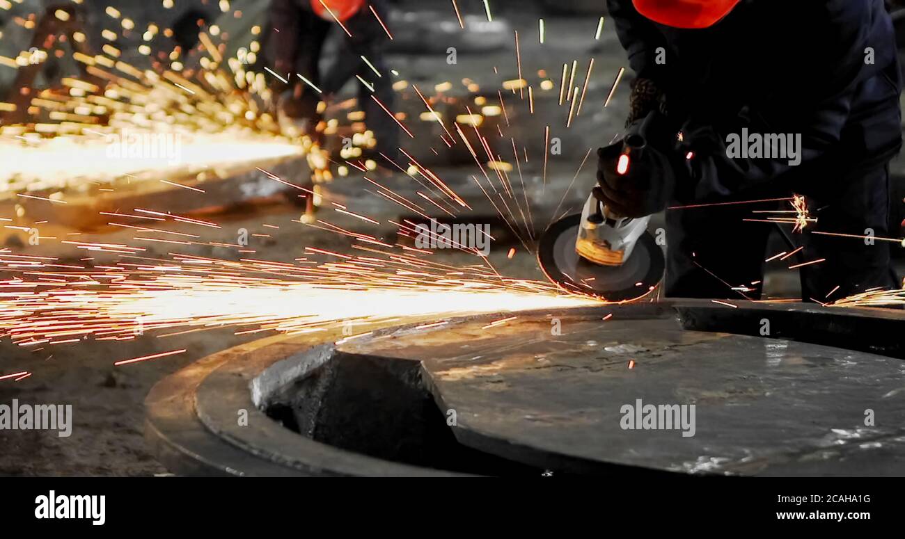 Working in a mask and headphones cleans joints angle grinder on metal ...