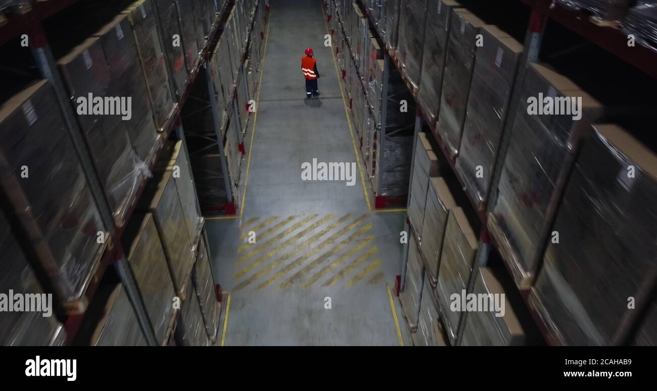 warehouse worker driver in uniform loading cardboard boxes by forklift ...