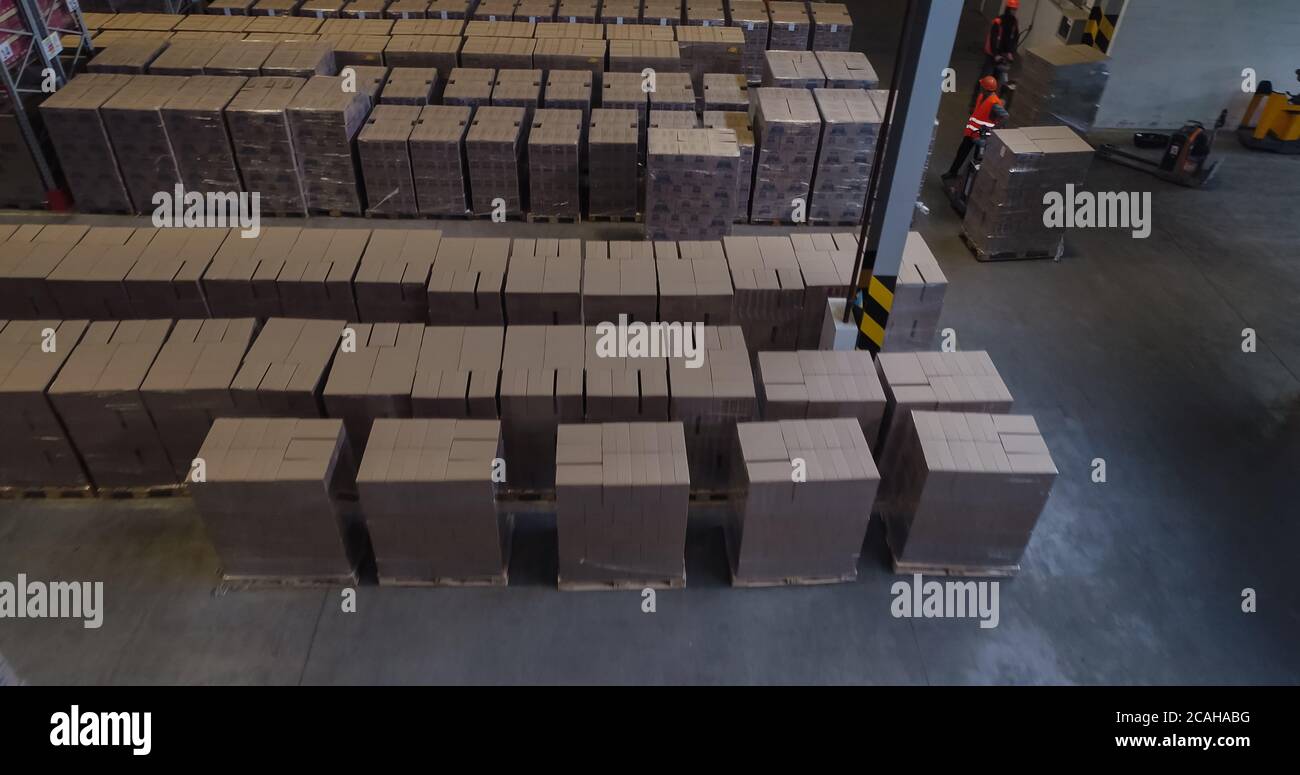 warehouse worker driver in uniform loading cardboard boxes by forklift ...