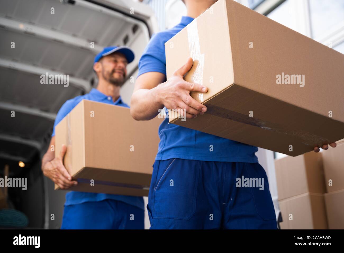 Truck Movers Loading Van Carrying Boxes And Moving House Stock Photo ...