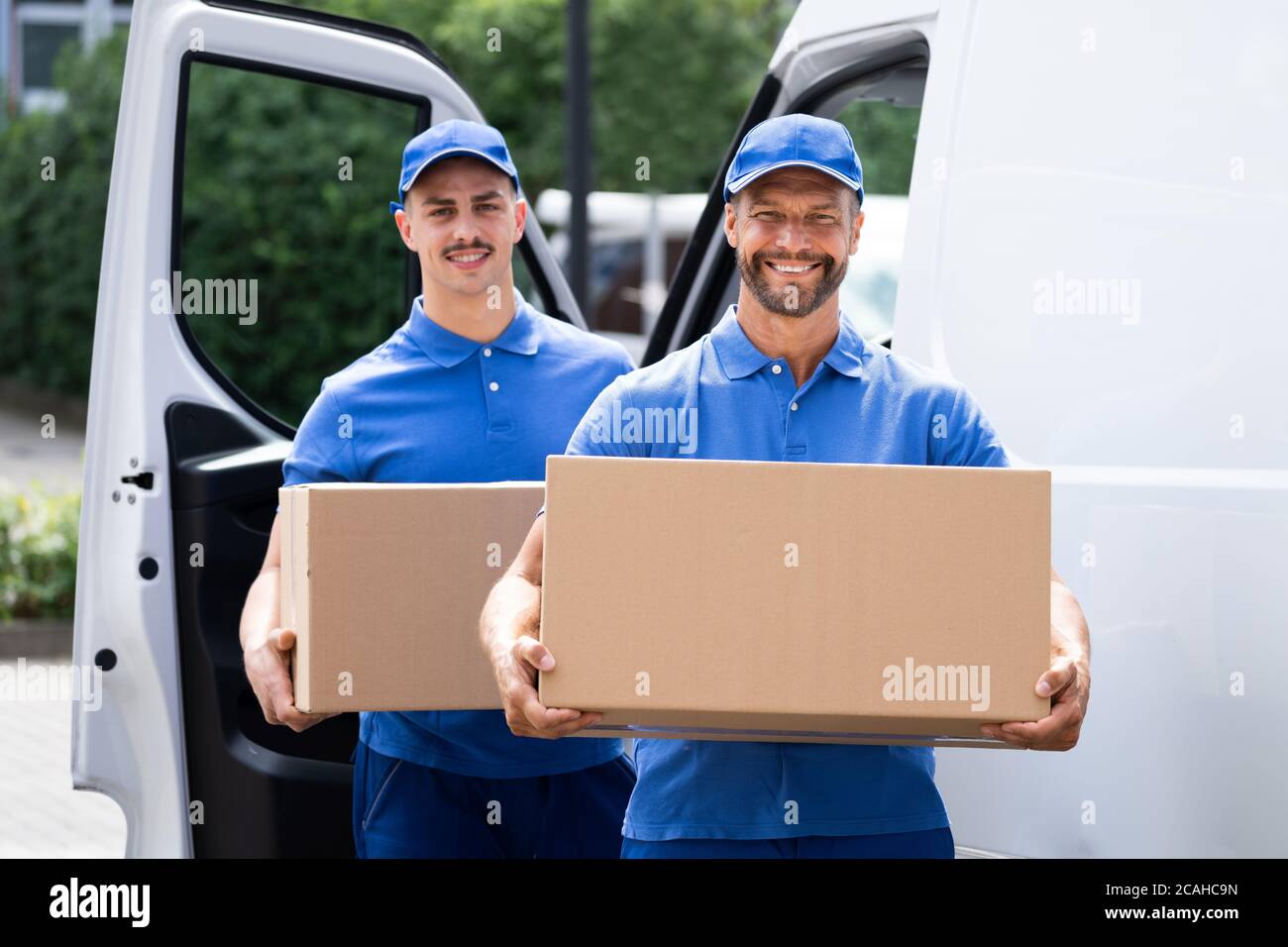 Delivery man carrying boxes on a hand truck hi-res stock photography ...