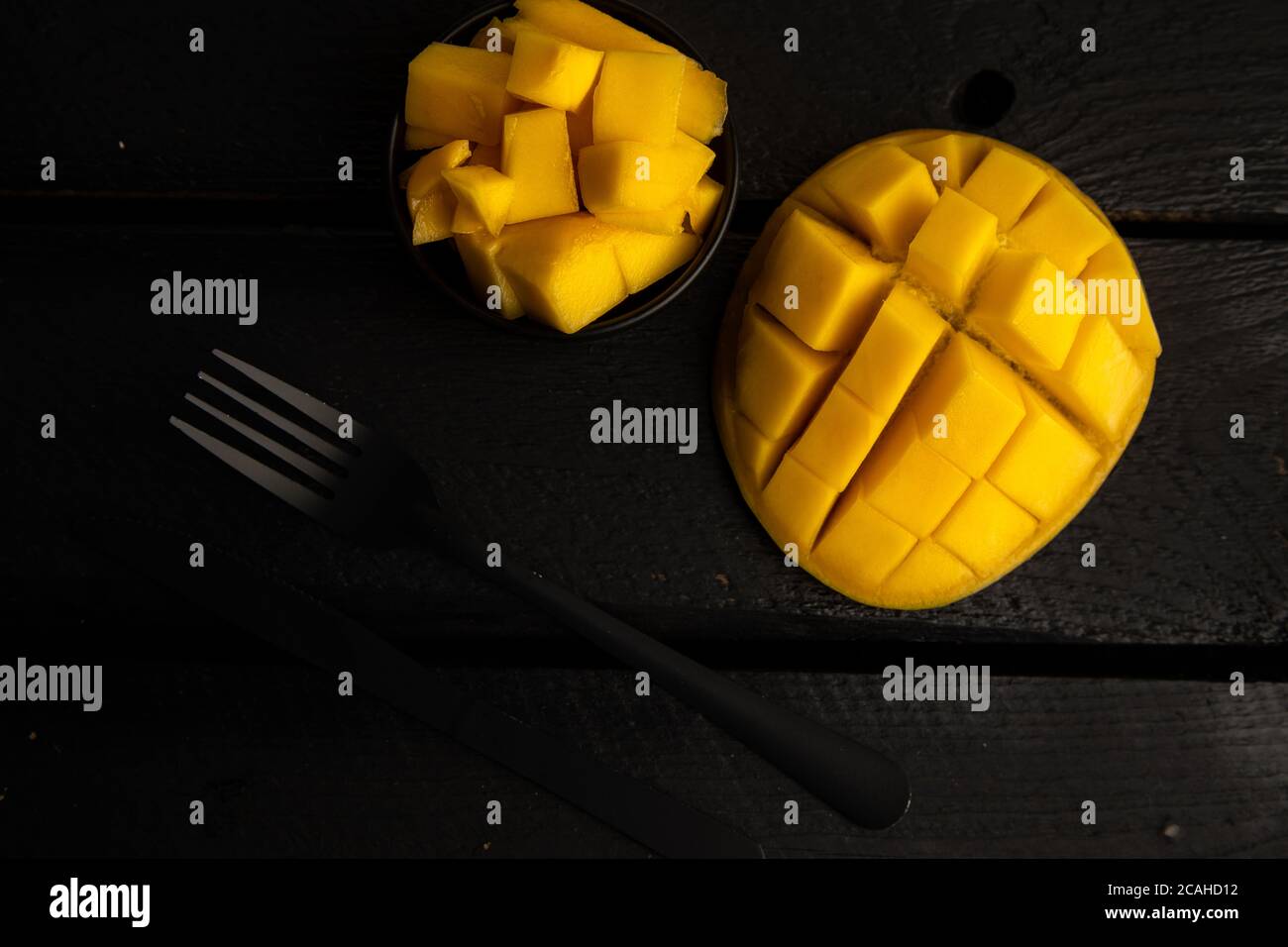 Top view closeup of mangoes cut into cubes on a black table Stock Photo ...