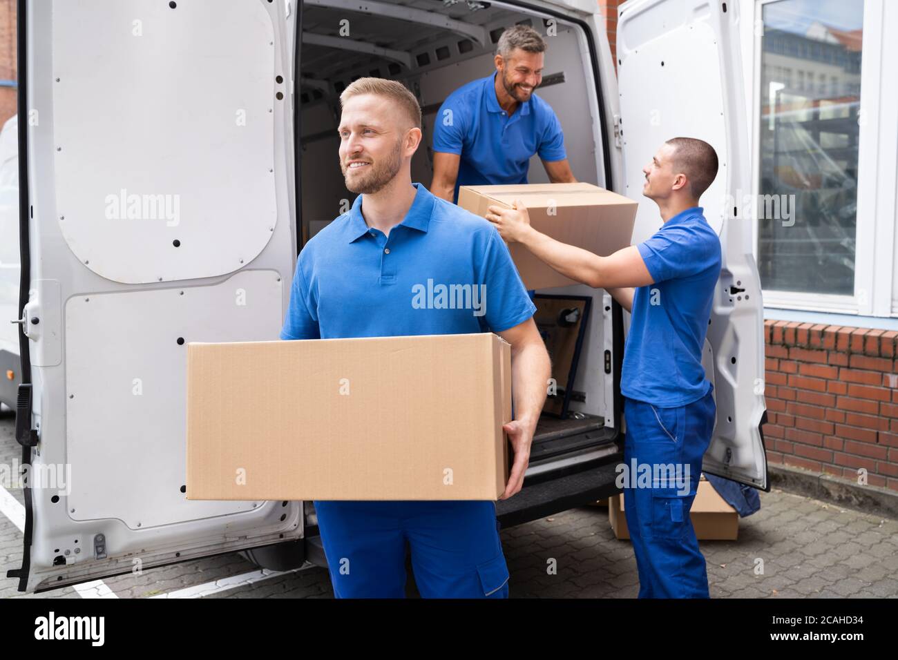 Truck Movers Loading Van Carrying Boxes And Moving House Stock Photo ...