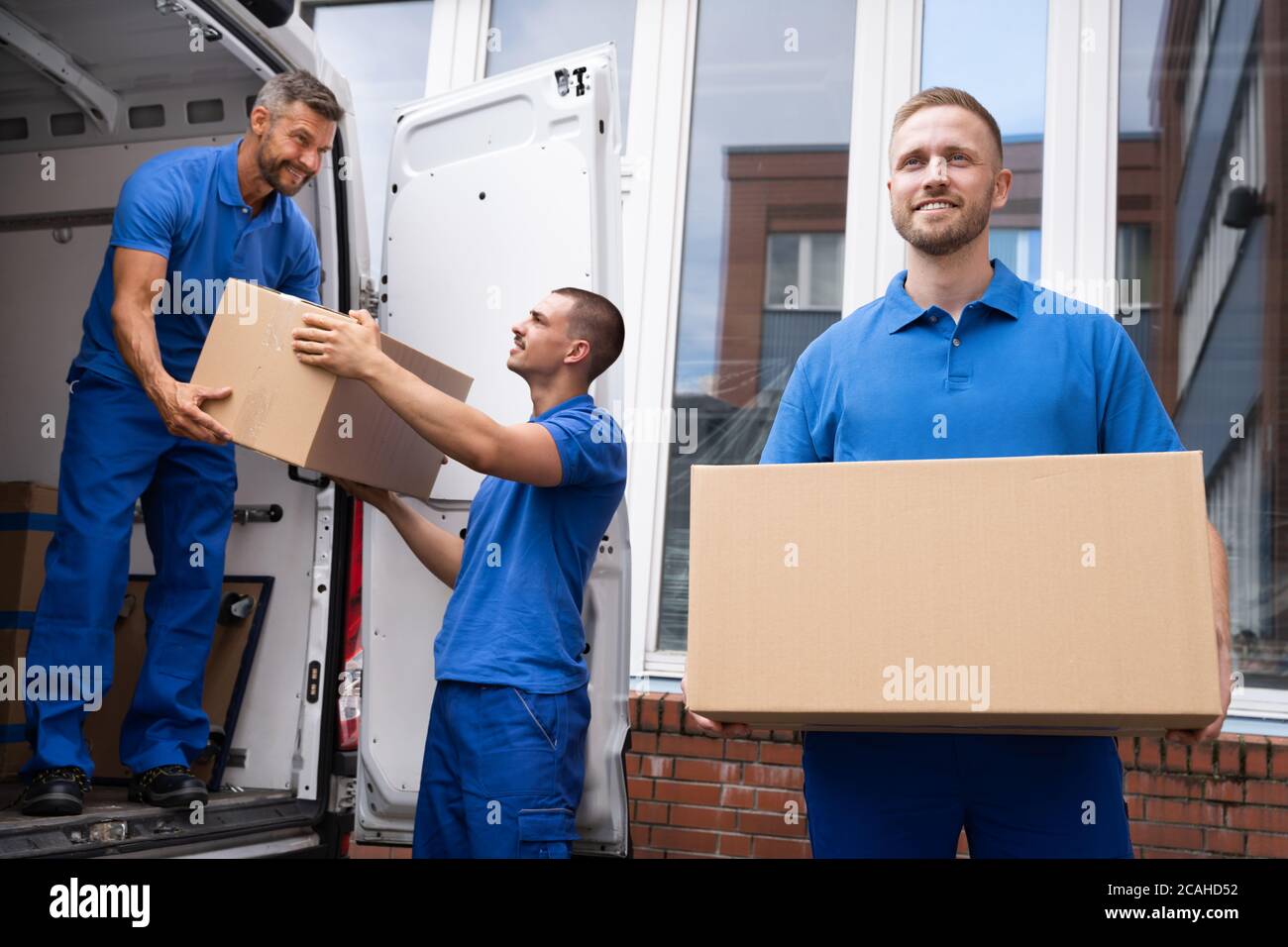 Group of people carrying boxes moving hi-res stock photography and ...
