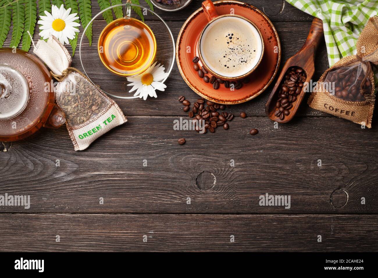 Herbal tea in teapot and cup and espresso coffee on wooden table. Top ...