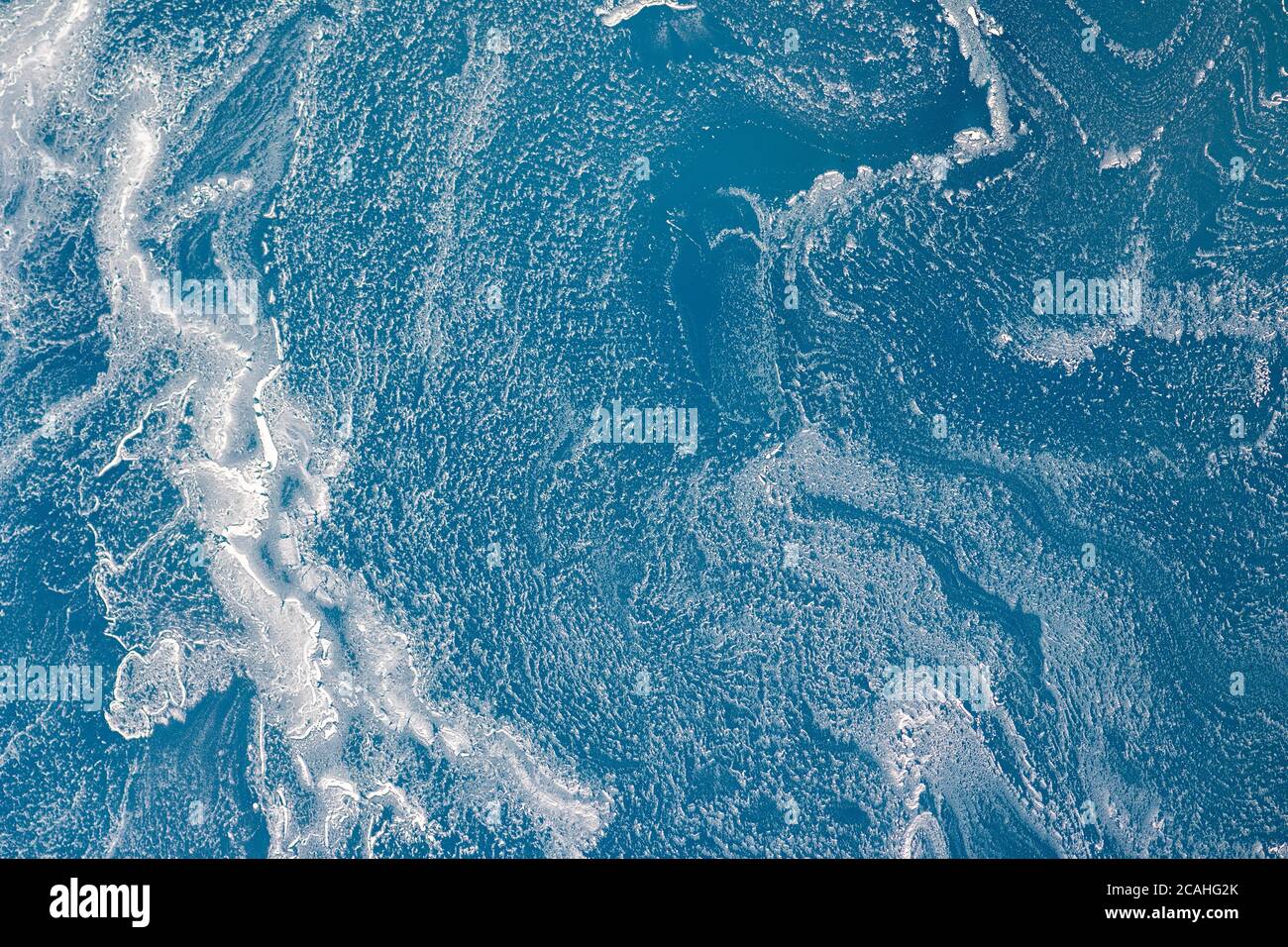 Abstract blue and white pattern in paint that evokes high level view of ...