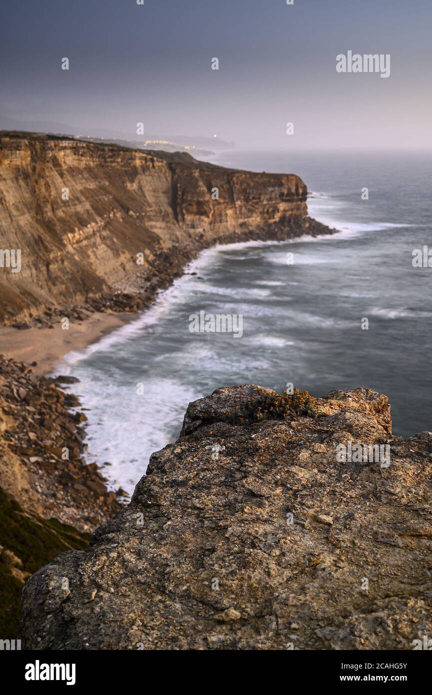 Beautiful wavy ocean hitting the beach surrounded by high cliffs Stock ...