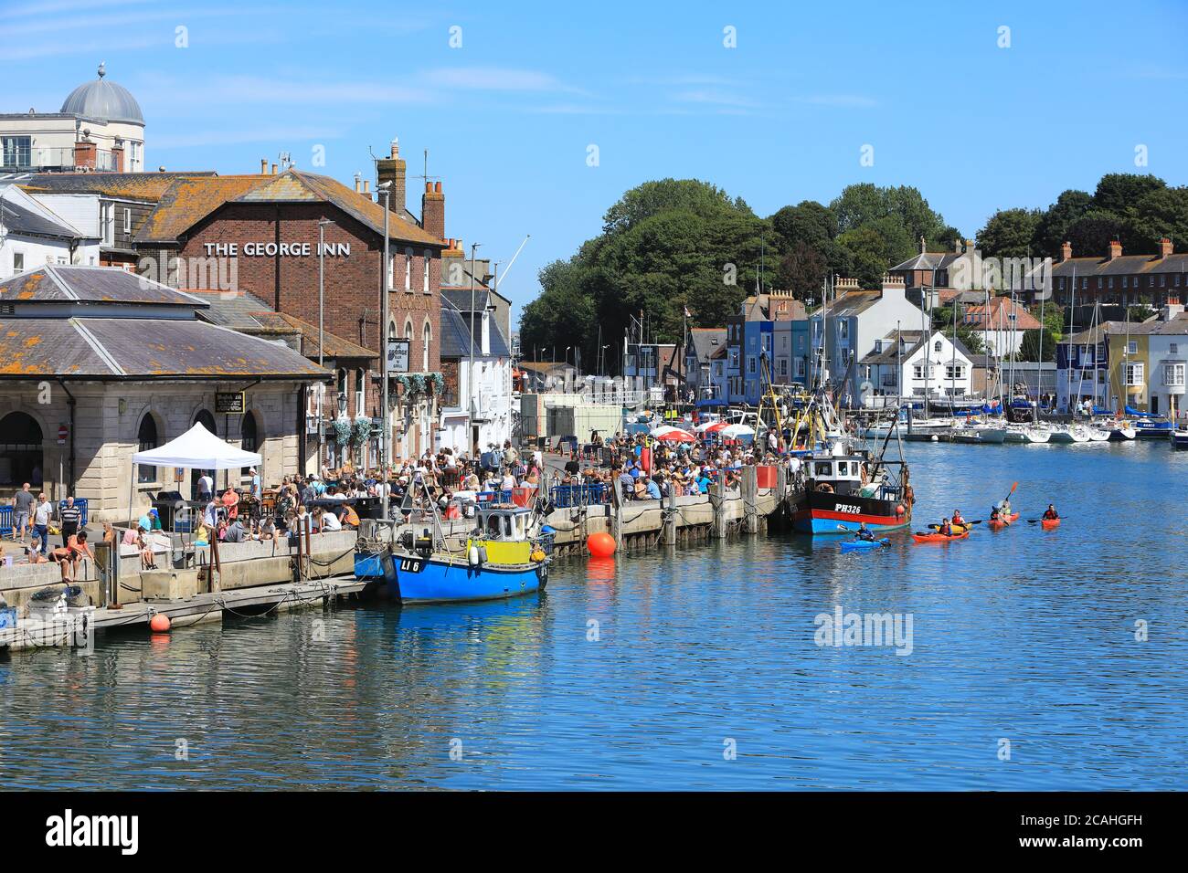 The pretty Old Harbour in Weymouth, Dorset, on a busy summer's day, on ...