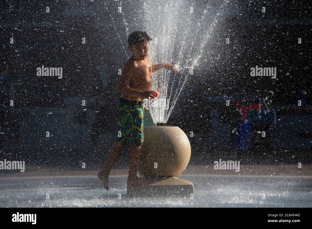 Boy cooling off in fountain, Piers Park, Boston, Massachusetts Stock ...