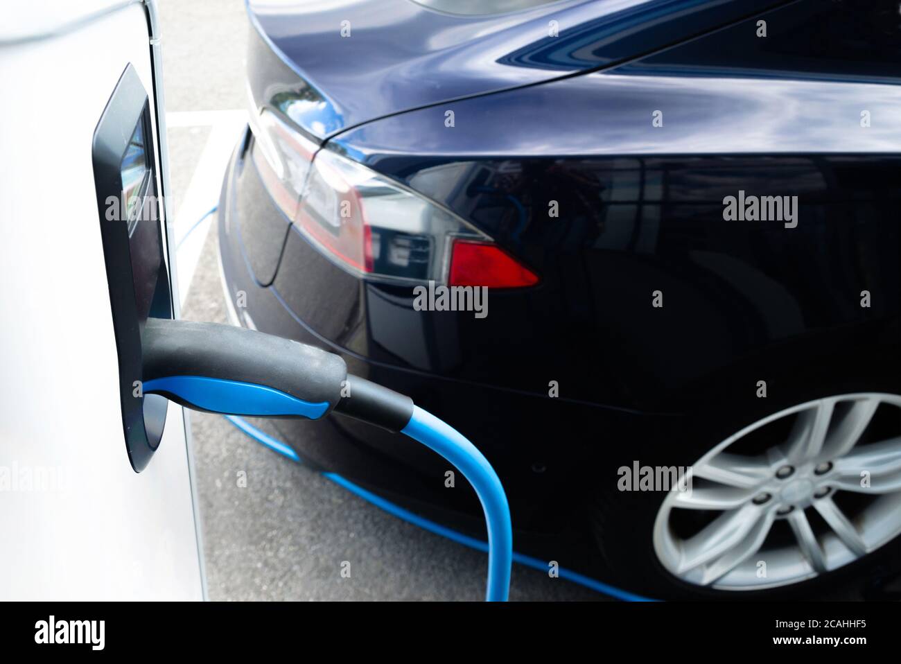 Modern electric car plugged in charging on the street station. New ...
