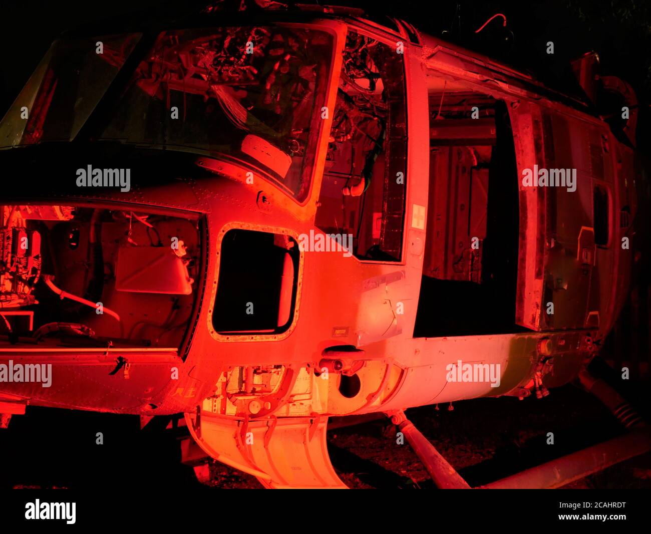 Disused abandoned Helicopter grounded at night with red night lighting ...
