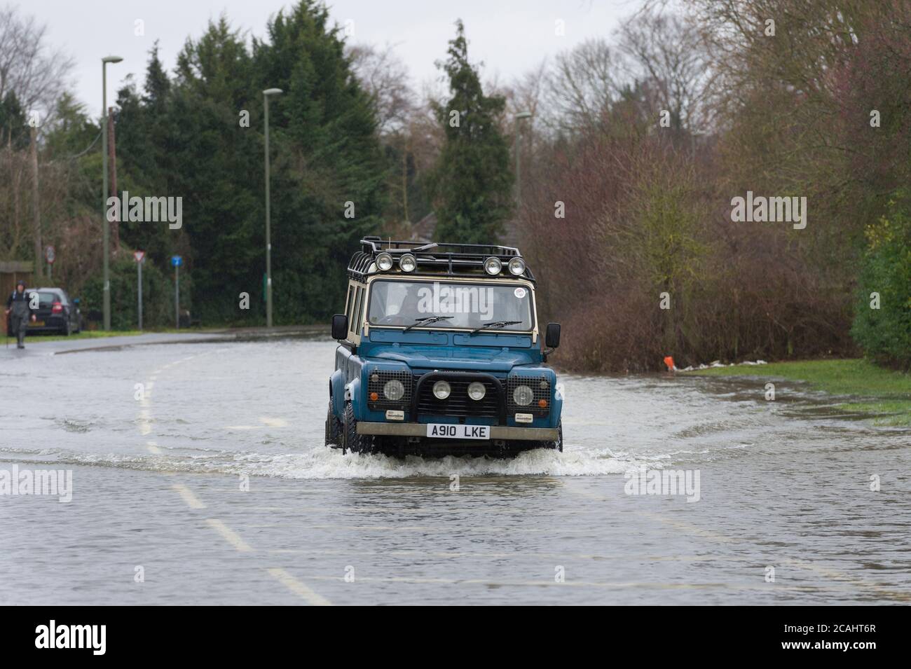 A car driving through flood waters on Chertsey Lane, Egham Hythe ...