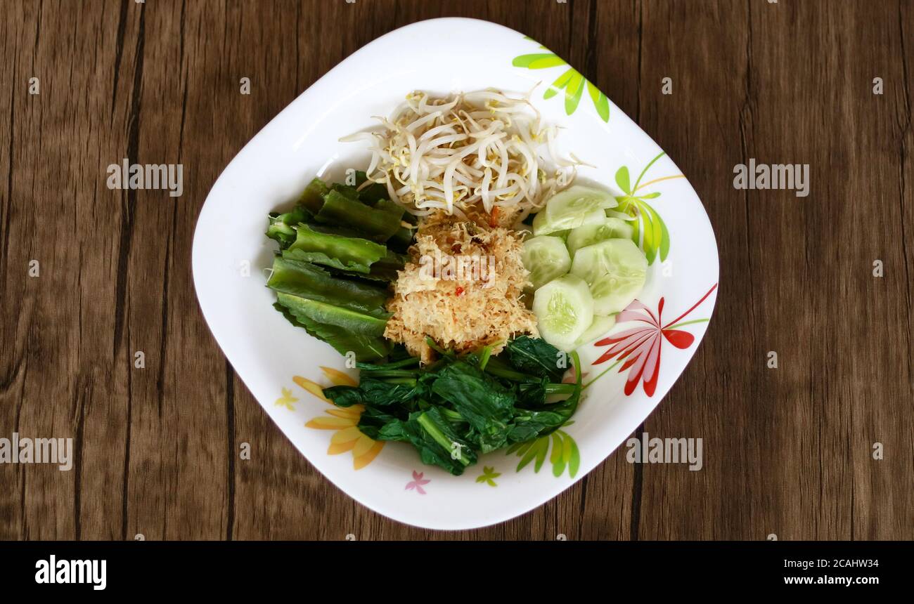 Sayur urap on wood background. Cooked vegetables with spiced grated ...