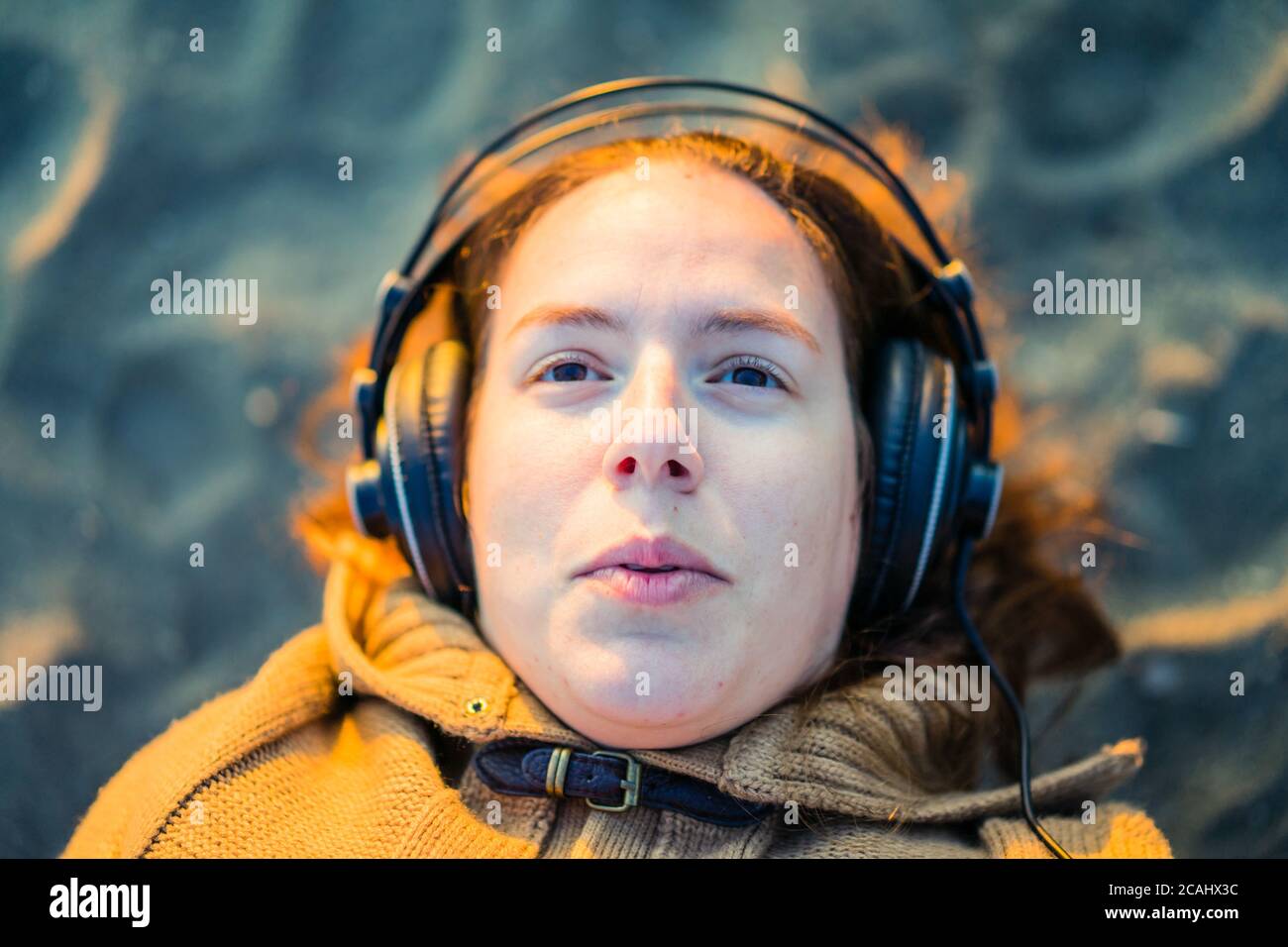 Closeup shot of a ginger caucasian female listening to music with ...