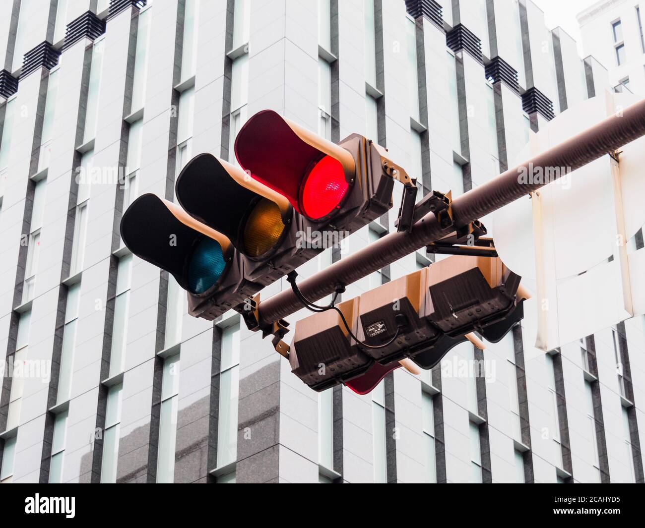 Low angle shot of hooded horizontal traffic lights hanging in a street ...