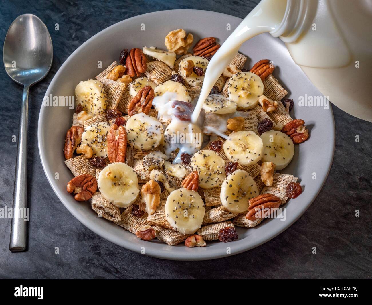 Closeup POV overhead shot of milk being poured from a carton over whole ...