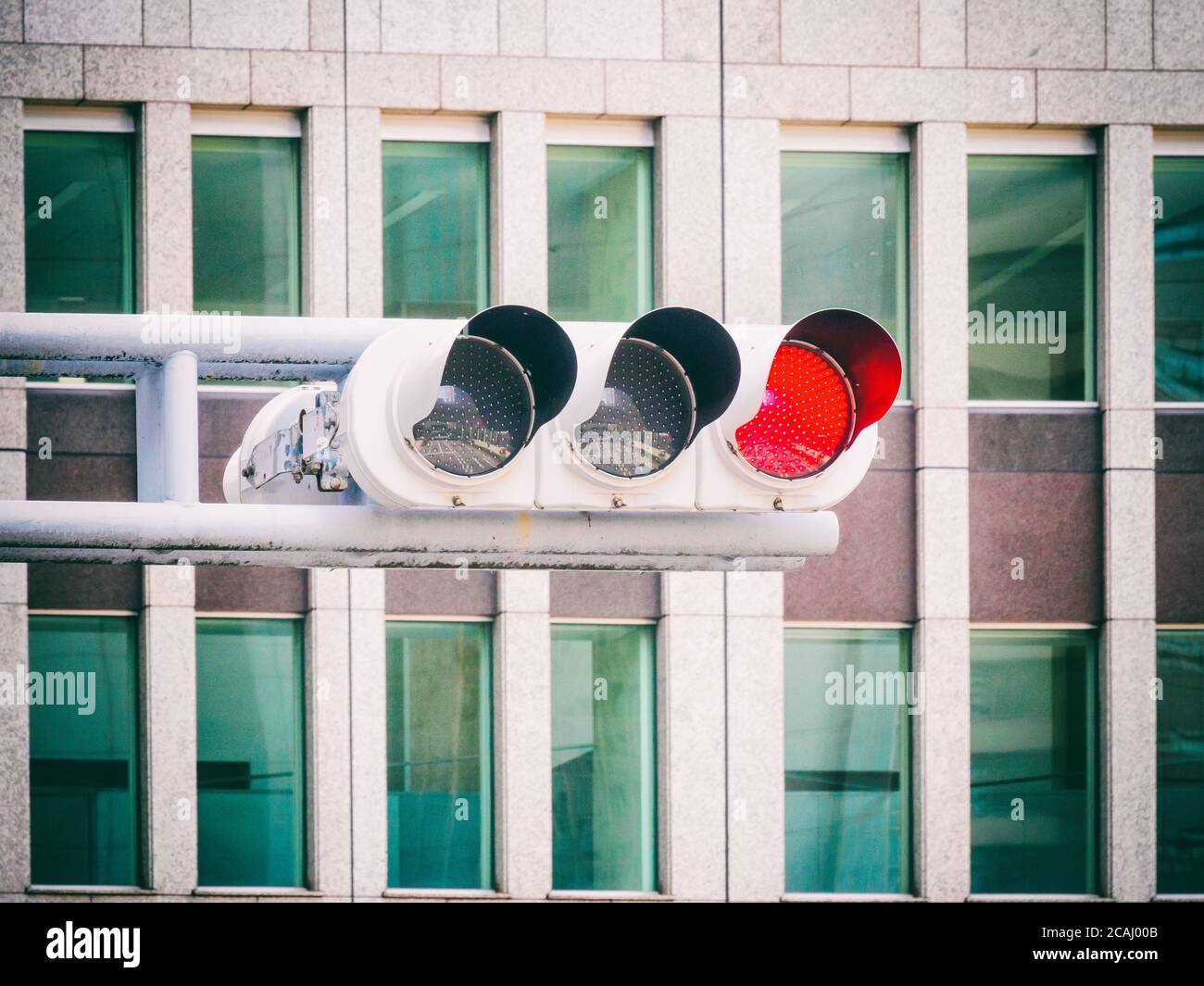 White horizontal traffic light with an illuminated red light on a pole ...