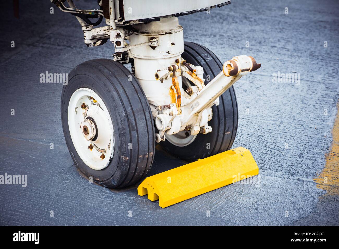 Closeup shot of industrial black wheels on a white machine and a yellow ...