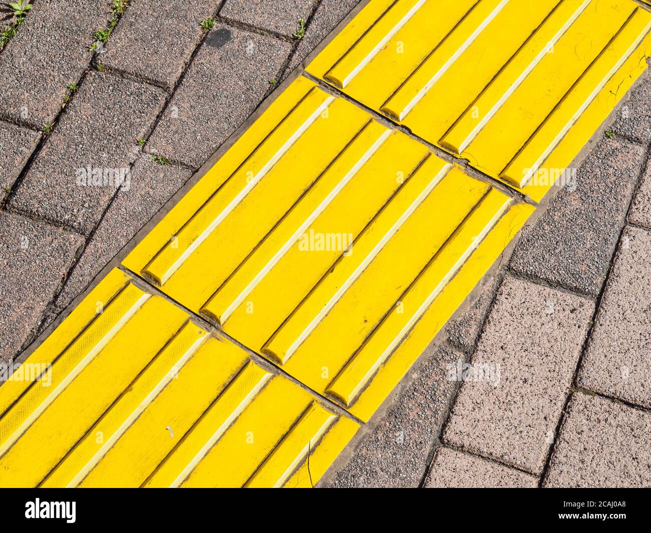 Closeup shot of textured yellow sidewalk sections for blind people ...