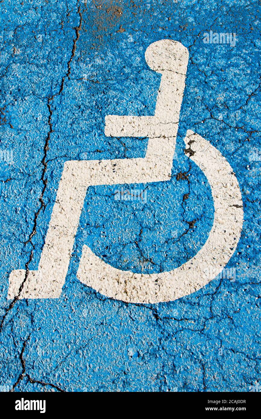 Vertical closeup shot of a white disabled person sign painted on a blue ...