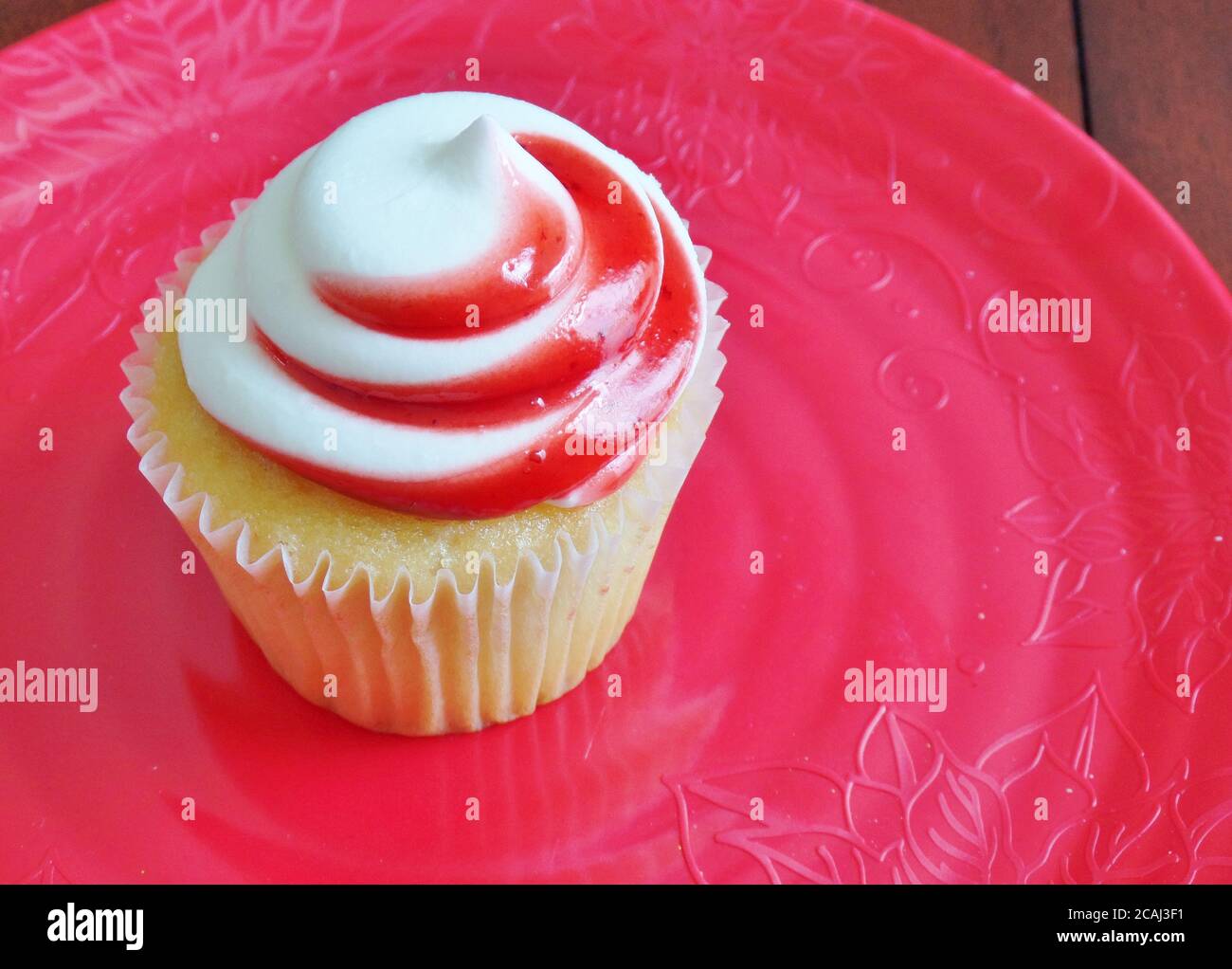 A cupcake with red and white frosting Stock Photo - Alamy